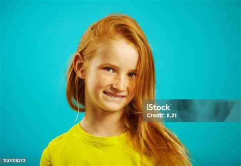 부끄러워 하는 아이 소녀의 초상화는 부끄러움을 표현 하 고 노란 T 셔츠를 입고 아름 다운 붉은 머리와 주 근 깨를가지고 있으며 귀여운 아이의 초상화는 파란색으로 고립 되어