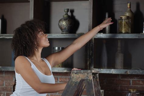 Mujer Cogiendo Algo De Estanter A Foto Gratis