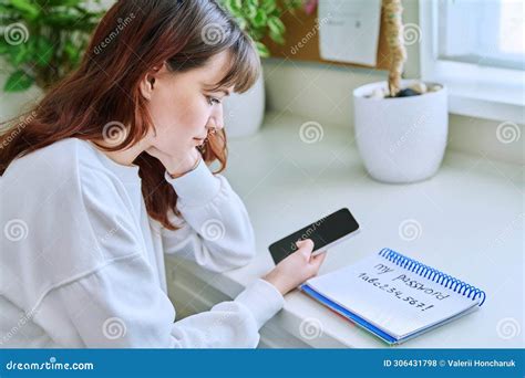 girl user typing password on smartphone on web verification page stock