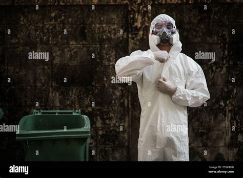 Man In Personal Protective Equipment Ppe Suit Wearing Clear Glasses And Gas Mask Preparing To