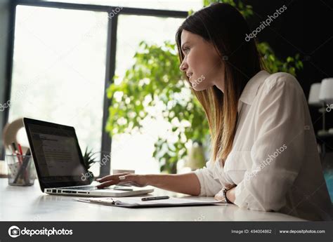 Beautiful Female Data Analyst Sitting At The Table Works On A Laptop Stylish Woman In The