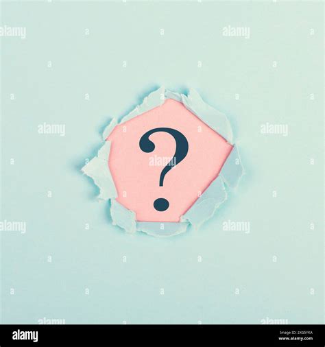 question marks on pink colored torn paper light blue background
