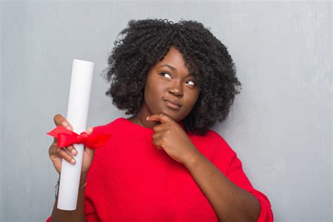 질문 매우 혼란 스 러 워 아이디어에 대 한 디플로마 심각한 얼굴 생각 들고 회색 그런 지 벽에 젊은 아프리카계 미국인 여자