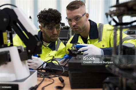 제조 자동화 및 로봇 작업장에서 Ai 로봇 및 사물 인공 지능 서비스 로봇을 구축하고 테스트하는 두 명의 남성 엔지니어 20