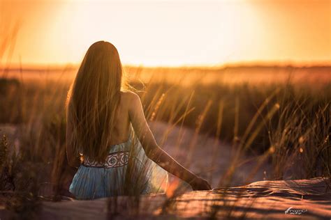 Обои на рабочий стол Девушка сидит на песке к нам спиной фотограф Antonio A Conde обои для