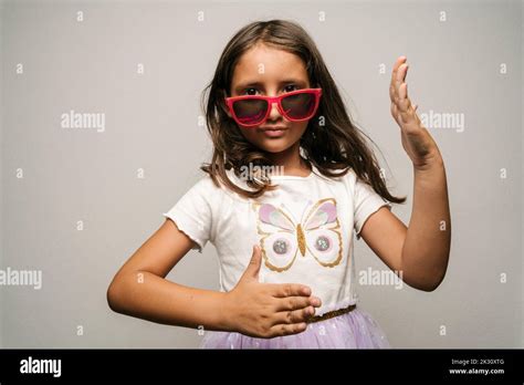 Girl Wearing Sunglasses Doing Robot Dance Against Gray Background Stock
