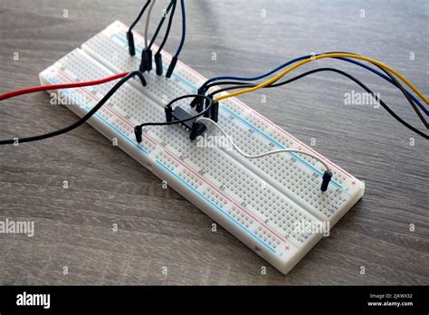 Micro Chip And Wires On Breadboard For Electrical Engineering On Wooden Table Stock Photo Alamy