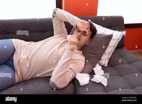 Non Binary Man Lying On Sofa Using Napkin At Home Stock Photo Alamy