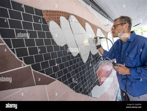Artist Bjorn Carnemalm Is Touching Up The Tile And Mosaic Joints On His
