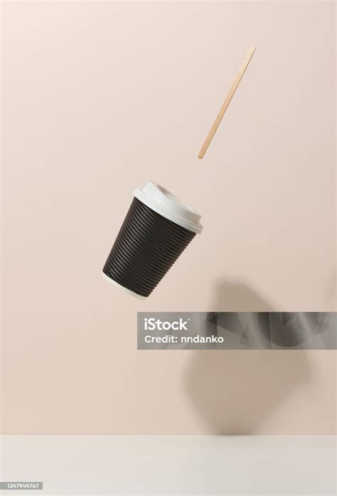흰색 플라스틱 뚜껑이 있는 갈색 골판지 컵과 나무 교반 스틱이 흰색 테이블에 부풀어 오있습니다 베이지 색 배경 커피숍 템플릿 0