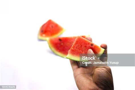 흰색 배경에 고립 된 수박 슬라이스 의 그룹을 디포커스와 손에 신선한 잘 익은 수박 슬라이스의 클로즈업 보기 열대 과일 건강한 식사 여름 배경 개념 건강한 생활방식에 대한
