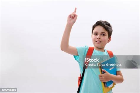 똑똑한 남학생 잘생긴 10대 초반 소년이 카메라를 보며 미소를 짓고 하얀 고립된 배경에 복사 공간을 가리킨다 가리키기에 대한 스톡 사진 및 기타 이미지 Istock