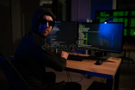 Hacker Sitting At Desk In Dark Atmosphere A Computer Programmer Or
