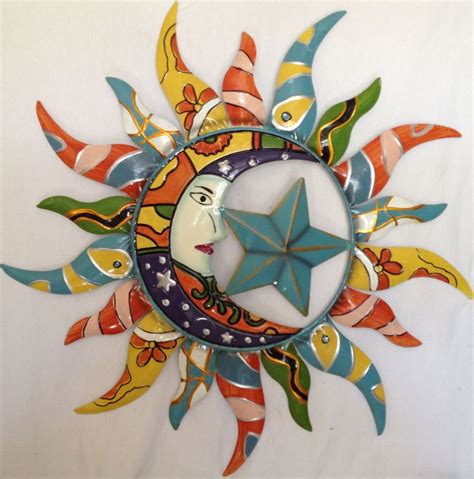 A Metal Sun And Moon Decoration On A White Wall With Blue Star In