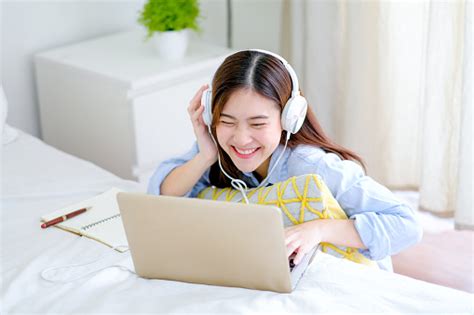 아름다운 여자는 노래를 듣고 아침 빛과 침실에서 노트북을 즐길 수있는 헤드폰을 착용 개념에 대한 스톡 사진 및 기타 이미지 개념 개념과 주제 금융 Istock