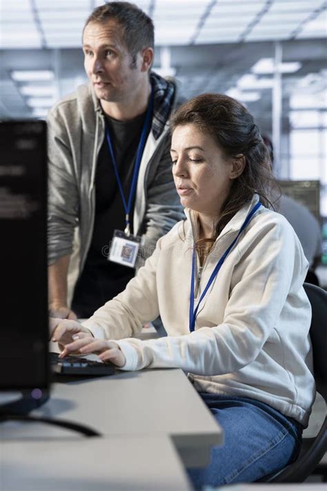 Team Leader Overseeing Employee Coding On Computer In Server Room Stock
