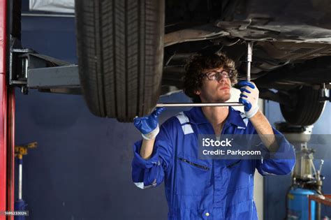남자 기술자 자동차 정비사는 제복을 입고 수리 차고 역에서 리프트 자동차 서비스를 점검하거나 유지 보수합니다 렌치를 잡고 고장 차량을 고정하는 작업자 자동차 센터 수리
