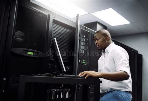 It Support Black Man Or Coding On Laptop In Server Room For Big Data