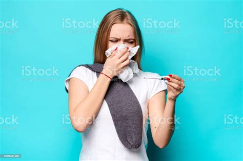 고립 된 배경에 스카프를 입은 젊은 여성이 온도계로 온도를 측정합니다 감기와 독감에 대한 스톡 사진 및 기타 이미지 감기와