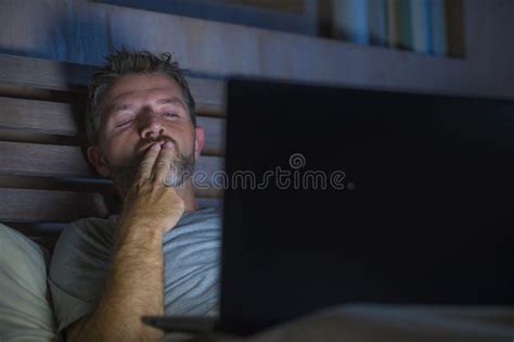 Man Alone In Bed Playing Cybersex Using Laptop Computer Watching Sex Movie Late At Night With
