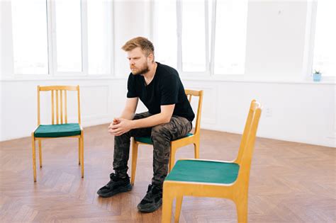 턱수염을 기른 슬픈 침묵의 남자가 그룹 치료 세션에서 원을 그리며 앉아 시선을 돌리는 원격 와이드 샷 정신 건강의 집단 상담의 개념 30 34세에 대한 스톡 사진 및 기타