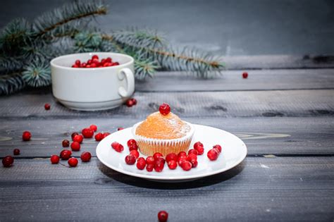 어떤 거짓말에 신선한 가문비나무 분기 컵 신선한 딸기의 신선한 구운된 머핀으로 빨간색 흰색 접시 빛 회색 나무 탁상 붉은 열매와 함께 장식 하 고 가루 설탕 갈색에 대한