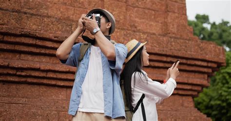 Happy Asian Traveler Couple With Hat Takes A Photo And Visits Ancient
