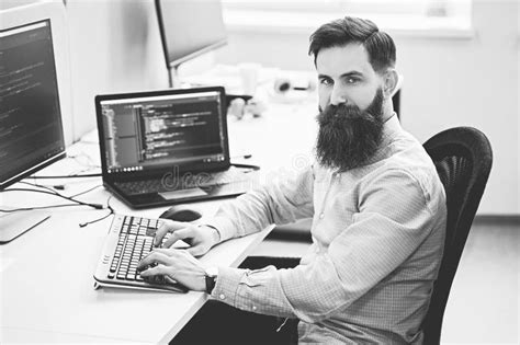 Computer Programmer Developer Working In It Office Sitting At Desk And