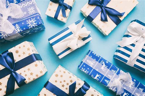 กล่องของขวัญคริสต์มาสจํานวนมากในกระดาษสีที่ตกแต่งบนโต๊ะมุมมองด้านบนอย่างใกล้ชิด ของขวั ภาพสต็อก