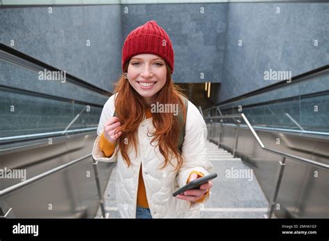 Outdoor Shot Of Young Woman Plans Route Follows Map On Smartphone App