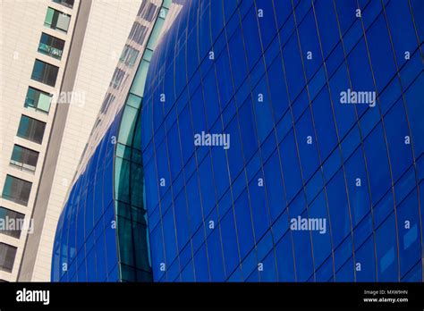 Close Shot Of A Modern Curved Blue Glass Window Wall Next To A