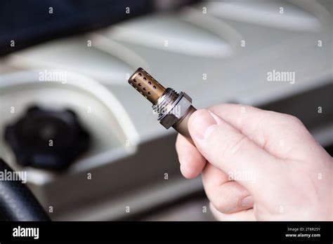 Oxygen Sensor For Gasoline And Diesel Engines In The Hand Against Car