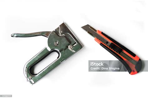 금속 태커 또는 대형 건설 금속 스테이플러 및 종이 절단 장비 커터 나이프 건설 큰 옵션 검은 색과 주황색 흰색 배경에 고립 된 가구 수리 도구 건축에 대한 스톡 사진 및
