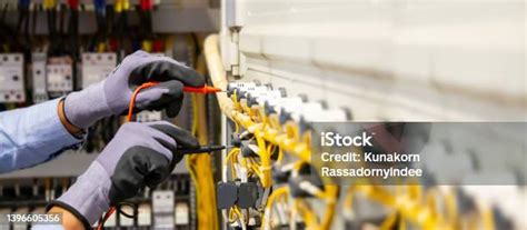 디지털 멀티 미터 측정 장비를 사용하여 주요 배전 기판에서 회로 차단기 및 케이블 배선 시스템에서 전류 전압을 검사하는 전기 엔지니어 전기공에 대한 스톡 사진 및 기타