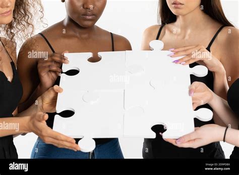Four Different Girls Hold A Puzzle In Their Hand Symbolically Connecting Puzzles As A Sign Of
