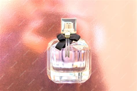 Premium Photo Perfume Bottle With Black Bow On Pink Background