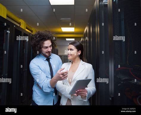 Young It Engineer Showing Working Data Center Server Room To Female Chief Engineer Who Holding