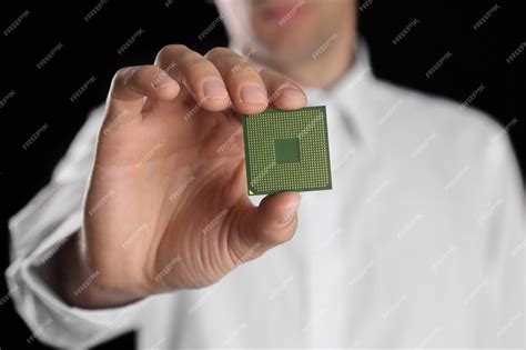 premium photo man holding microprocessor in his hand on black background