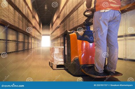 Workers Driving Electric Forklift Pallet Jack Unloading Packaging Boxes In The Warehouse