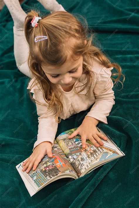 Девушка читающая книгу на одеяле Бесплатно Фото