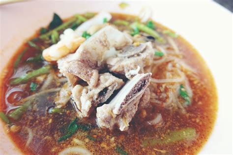 돼지 뼈 가재 새우와 매운 해산물 국수 수프 나무 테이블 배경에 분홍색 그릇에 아시아 음식입니다 태국 스타일의 국수와 태국의 길거리 음식 맨 위 보기 건강한 생활방식에 대한