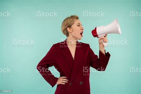 파스텔 블루 월 배경 스튜디오 초상화에 고립 포즈 빨간 정장에 재미 젊은 갈색 머리 여자 소녀 사람들은 진지한 감정 라이프 스타일 개념 복사 공간을 모의합니다 메가폰에서