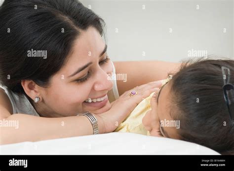 Close Up Of A Mid Adult Woman Lying On The Bed With Her Daughter Stock