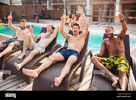 Handsome Young Smiling Men Having Fun In Swimming Pool And Drinking