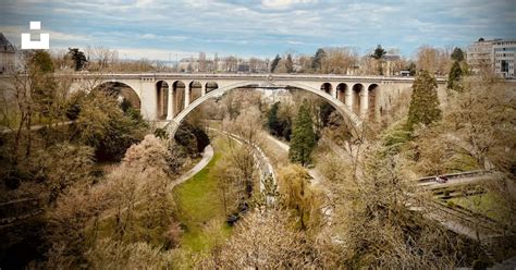 나무로 둘러싸인 강을 가로지르는 다리 사진 Unsplash의 무료 룩셈부르크 이미지