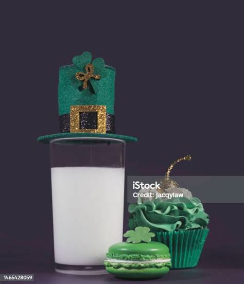 성 패트릭의 날 트리오는 레프러콘 모자에 우유 한 잔 녹색 마카롱 쿠키 반짝이는 체리를 얹은 초콜릿 컵케이크 등 아침의 정상을 위해 간식을 제공합니다 0명에 대한 스톡 사진