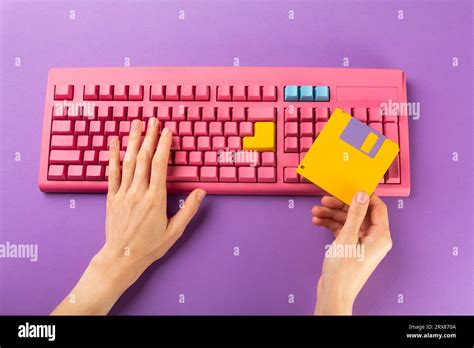 Hand Holding Floppy Disk On Color Keyboard Background Technology Concept High Quality Photo