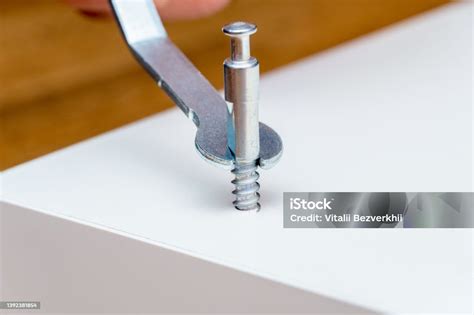 Furniture Assembling Process Screwing Tightening The Bolt With A Special Wrench Instrument Stock