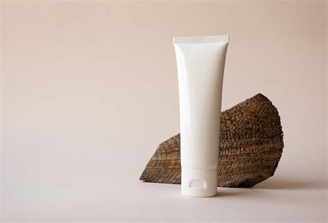 화이트 뷰티 스킨케어 제품 튜브와 질감이 있는 나무 나무 컷 표면을 베이지 색 배경에 브랜딩을 위한 에코 유기농 천연 화장품
