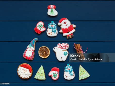 고전적인 파란색 나무 배경에 접시에 집에서 만든 진저 브레드 쿠키로 만든 크리스마스 트리 눈송이 별 나무 눈사람 사슴 모양 휴일 축하 및 요리 개념 닫습니다 12월에 대한